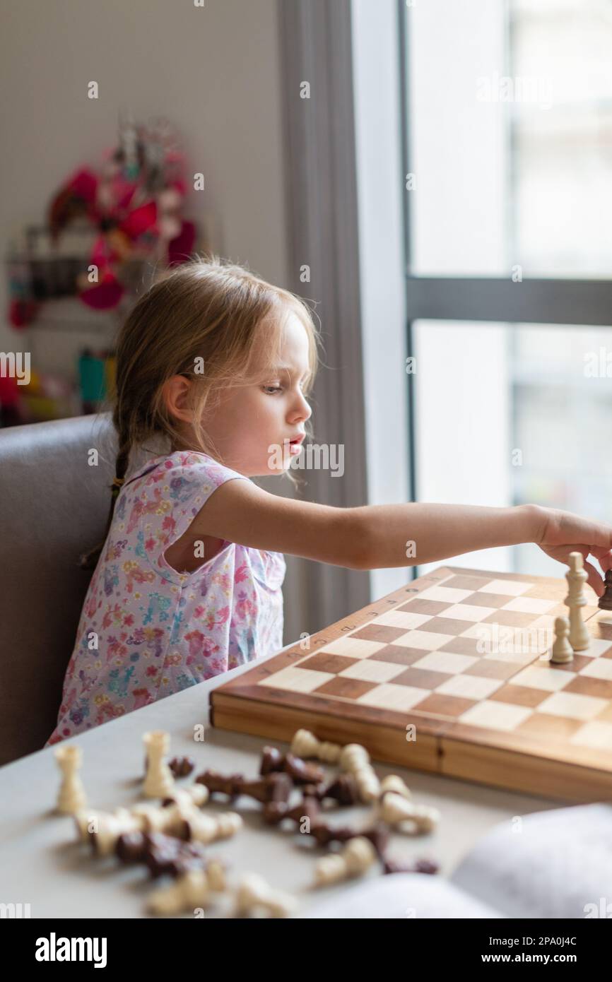 Little girl playing chess at home Stock Photo - Alamy