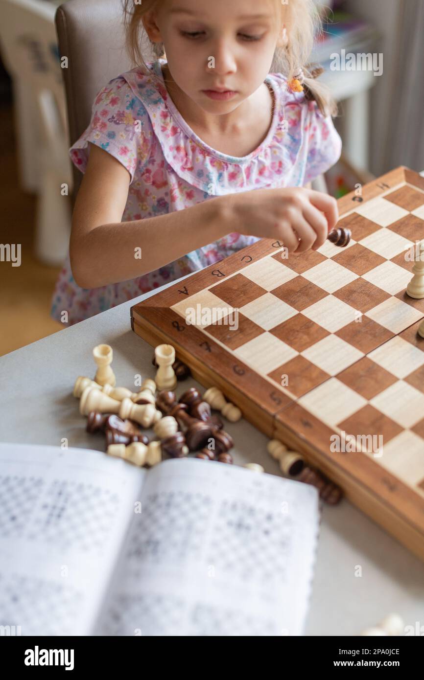 Little girl playing chess at home Stock Photo - Alamy