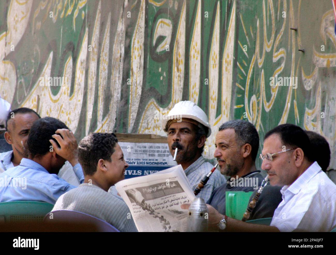 Egyptians smoke cigarettes and shishas, at a coffee shop in Cairo ...