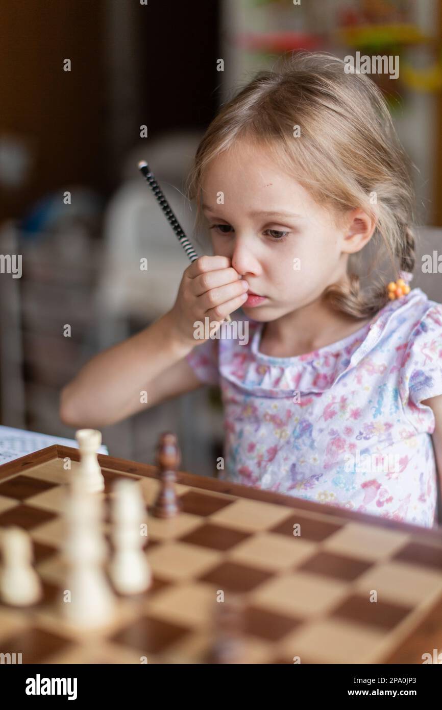 Little girl playing chess at home Stock Photo - Alamy
