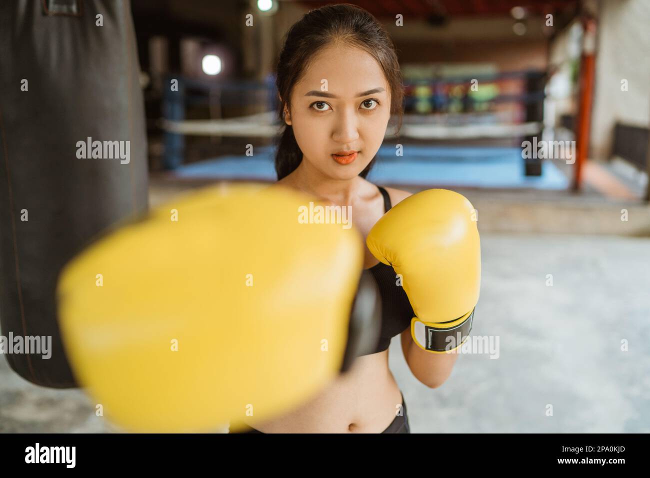 a beautiful boxer with yellow boxing gloves standing with punching ...