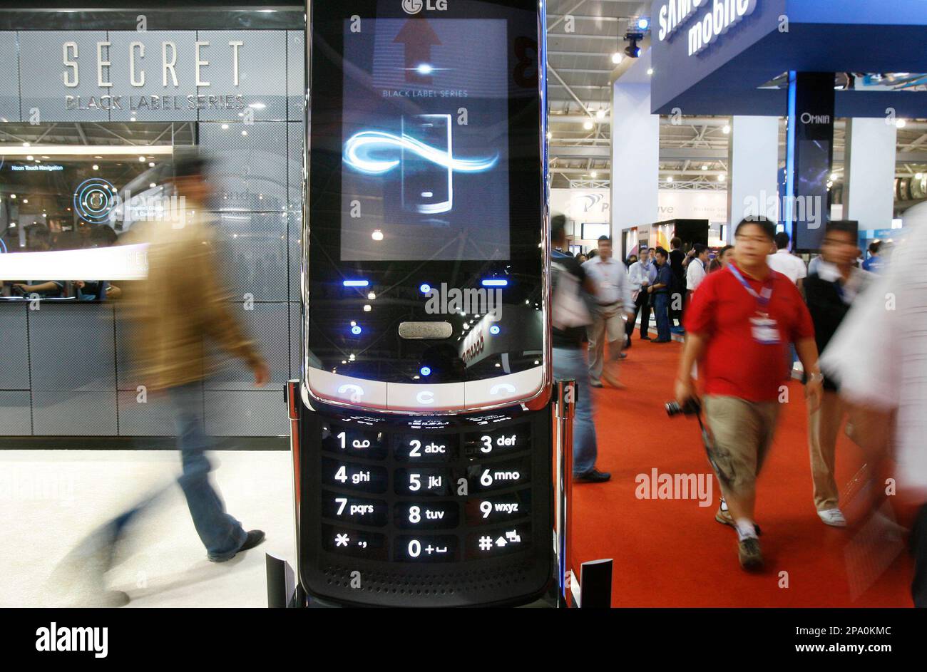 Visitors walk past a giant LG mobile phone during the CommunicAsia ...