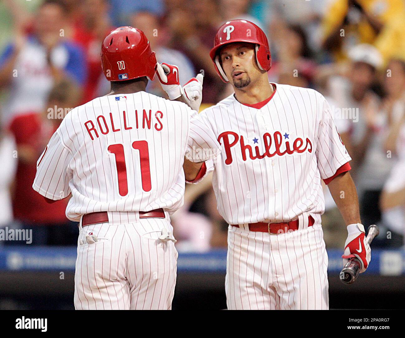 Philadelphia Phillies' Jimmy Rollins, left, is greeted at the plate by ...