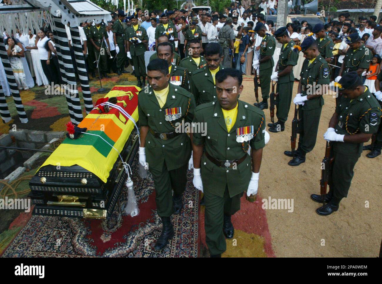 Sri Lankan soldiers march past a coffin which contains the remains of ...