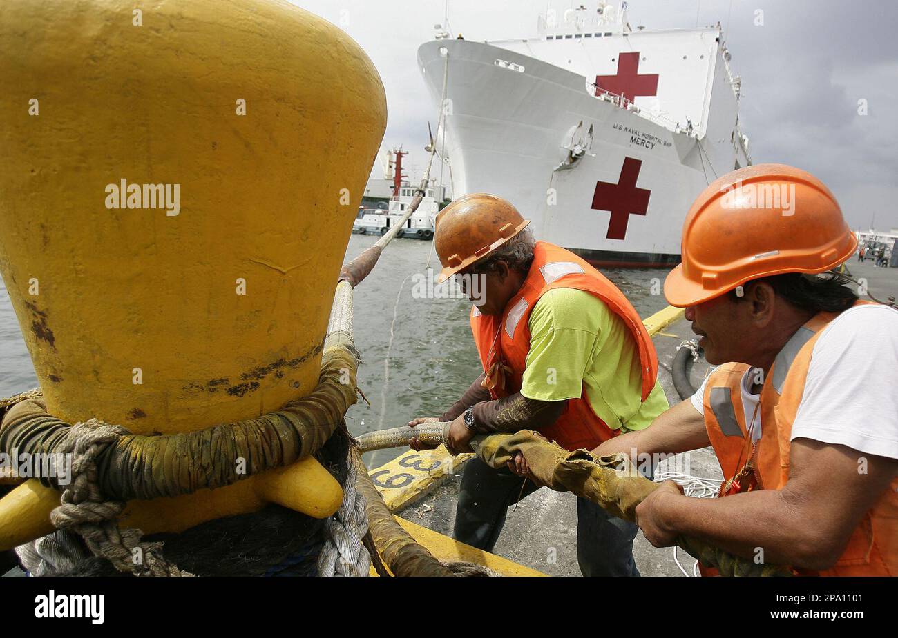 Filipino workers assist during the arrival of the U.S. naval hospital ...