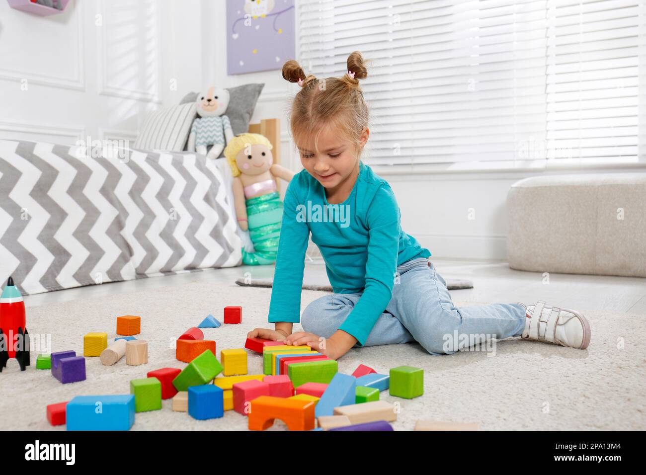 Cute little girl playing with colorful building blocks at home Stock ...