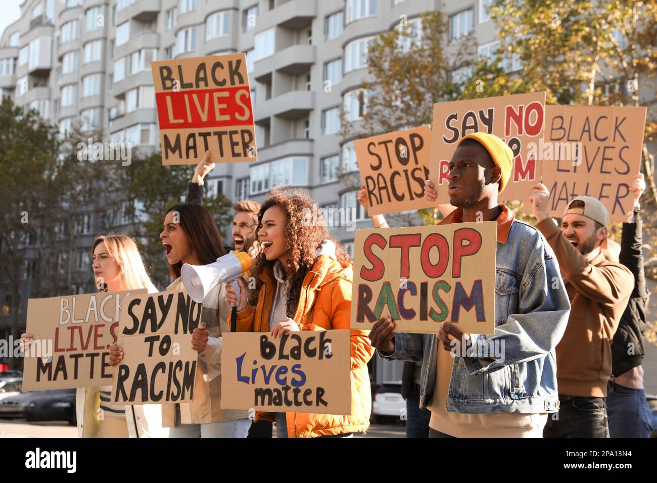 Protesters demonstrating different anti racism slogans outdoors. People ...