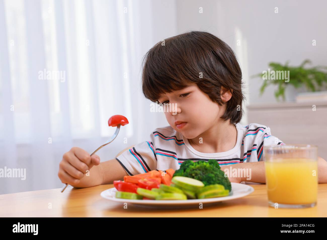 Cute little boy refusing to eat vegetables at home Stock Photo - Alamy