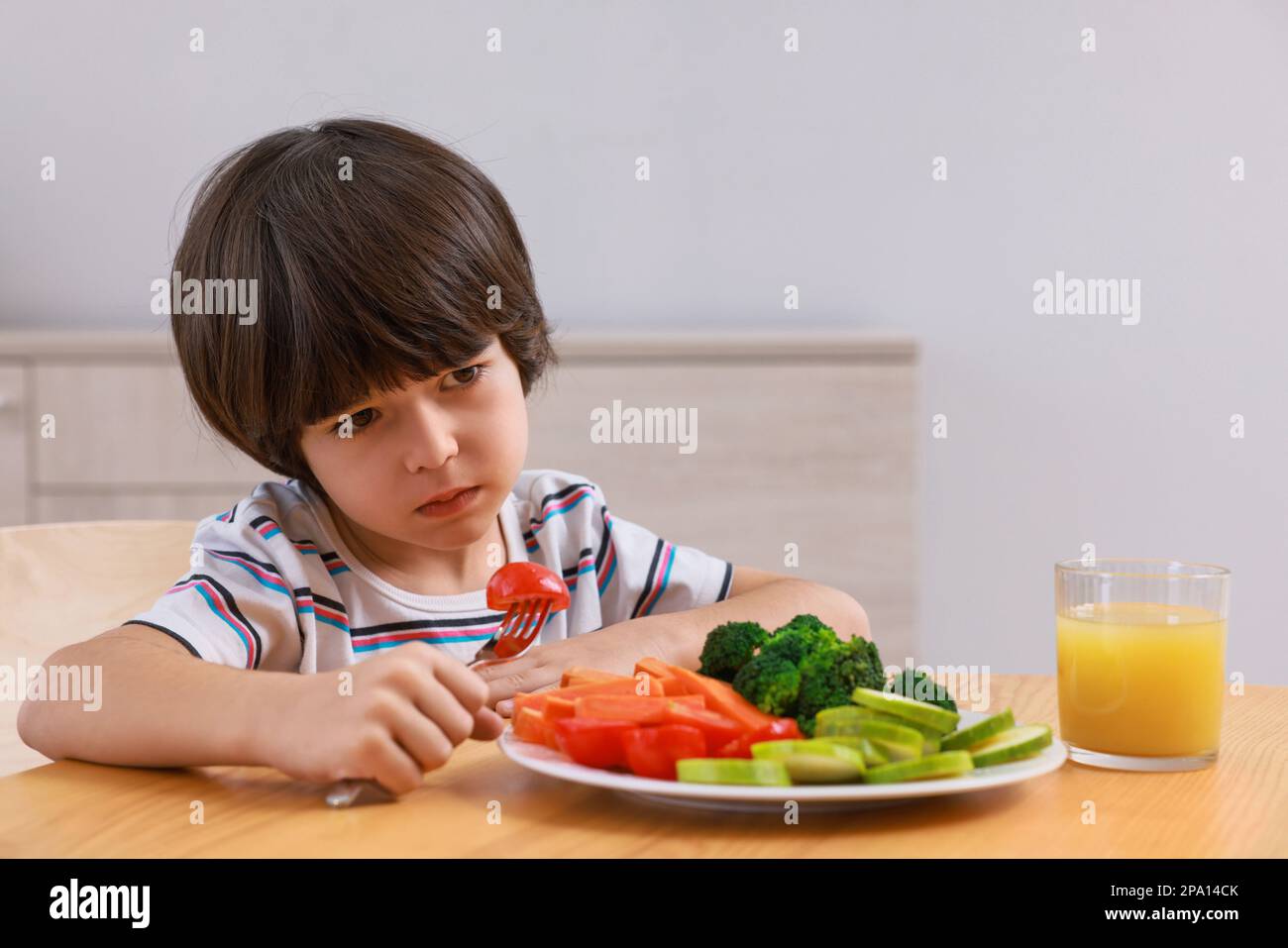 Cute little boy refusing to eat vegetables at home Stock Photo - Alamy