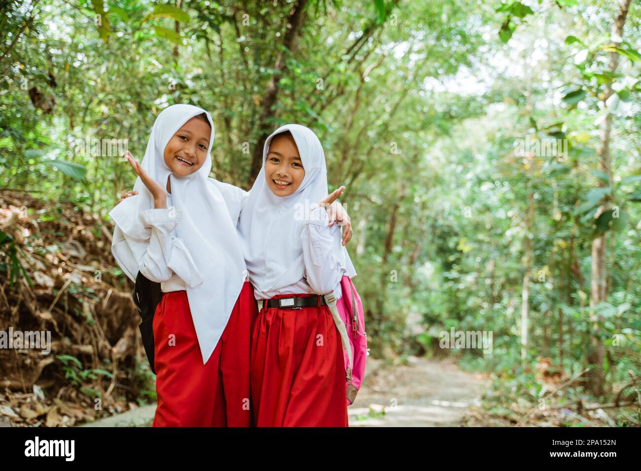 two beautiful elementary students standing together and hugging each ...
