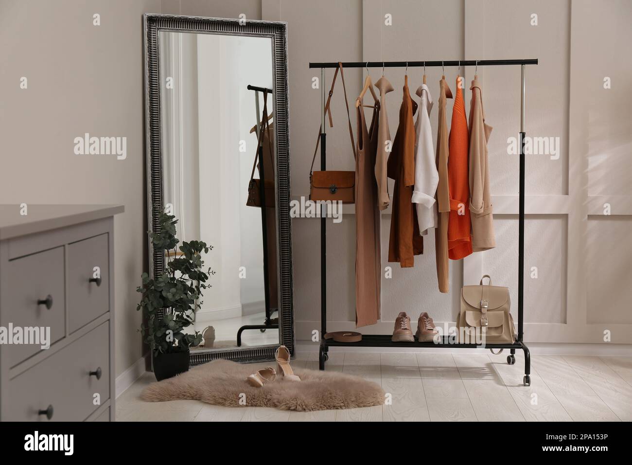 Rack with stylish women's clothes and mirror in dressing room Stock ...