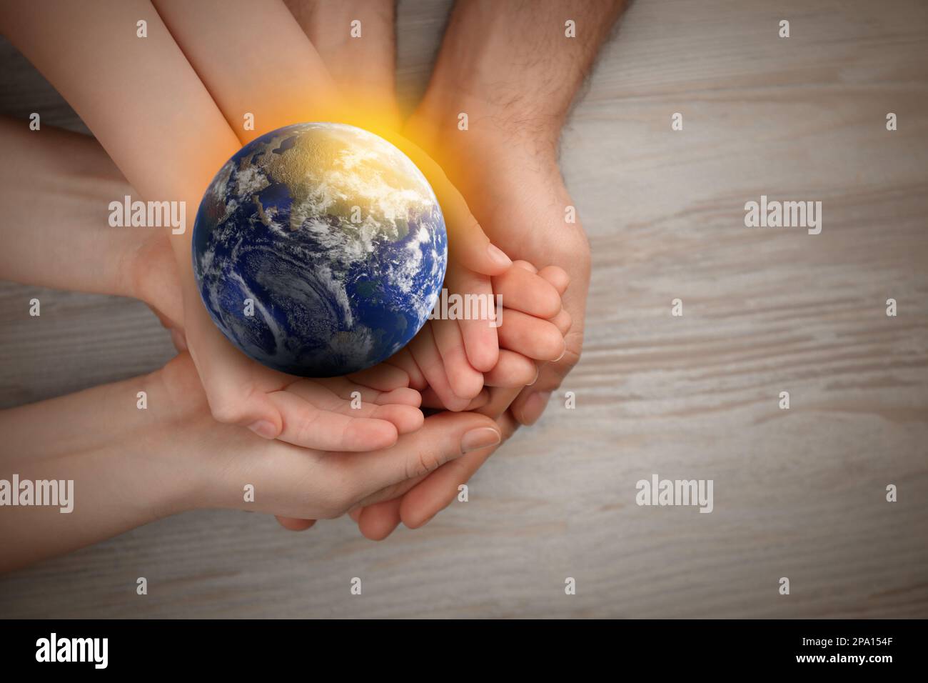 World in our hands. Top view of parents and kid holding digital model ...