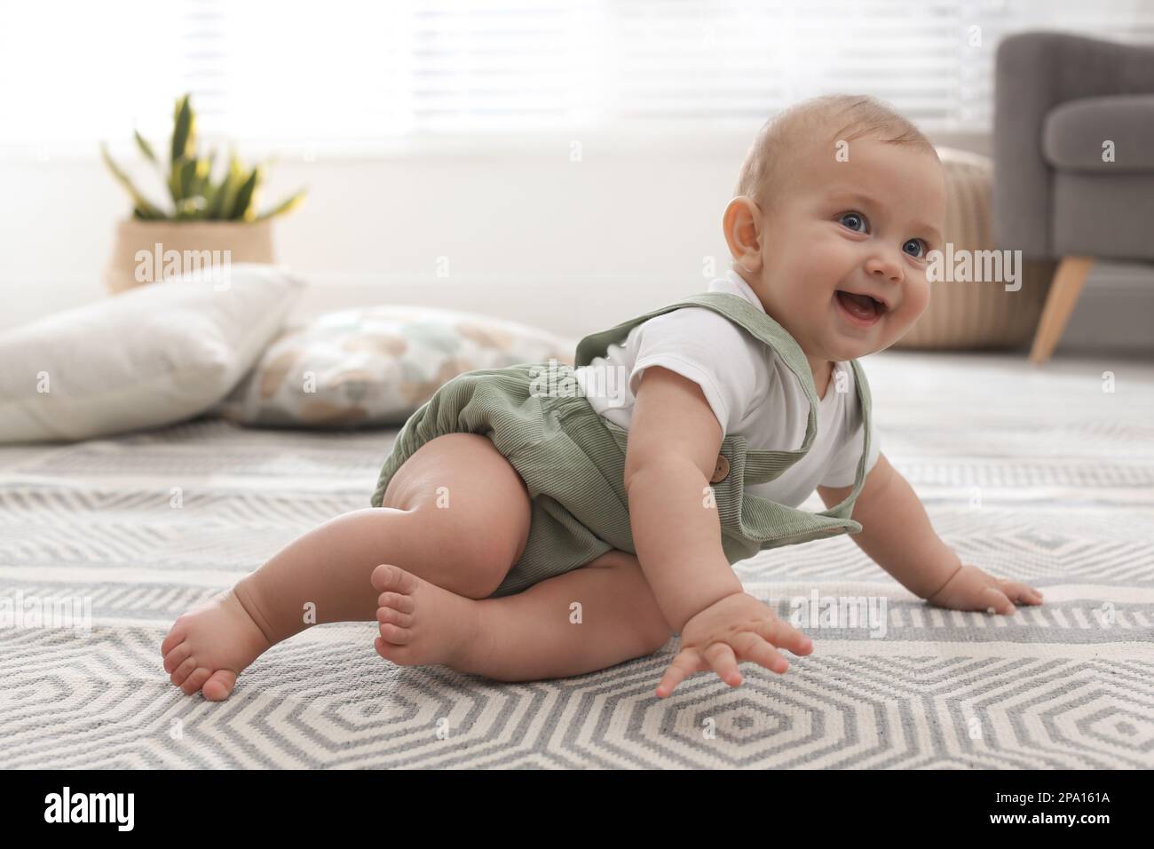 Cute baby crawling on floor at home Stock Photo - Alamy