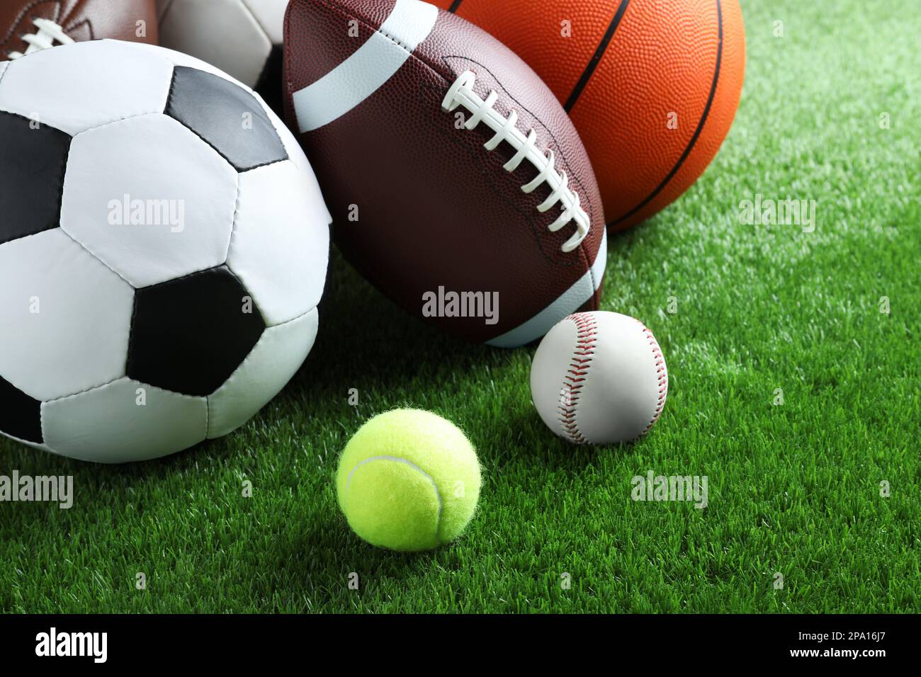 Set of different sport balls on green grass Stock Photo - Alamy