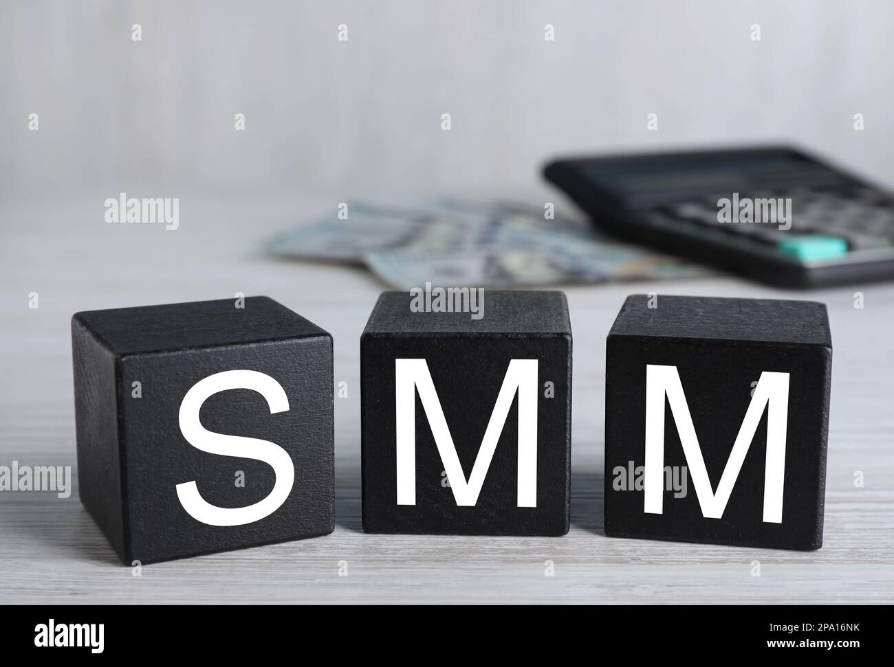Black cubes with abbreviation SMM (Social media marketing), money and ...