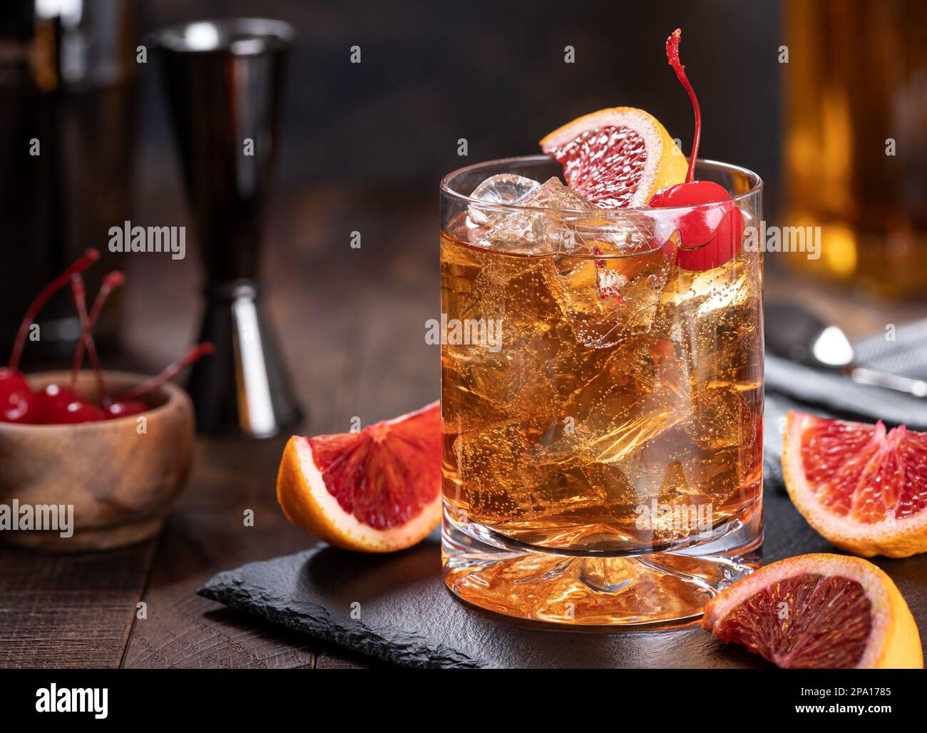 Old fashioned whiskey cocktail with cherry and orange slices on a ...