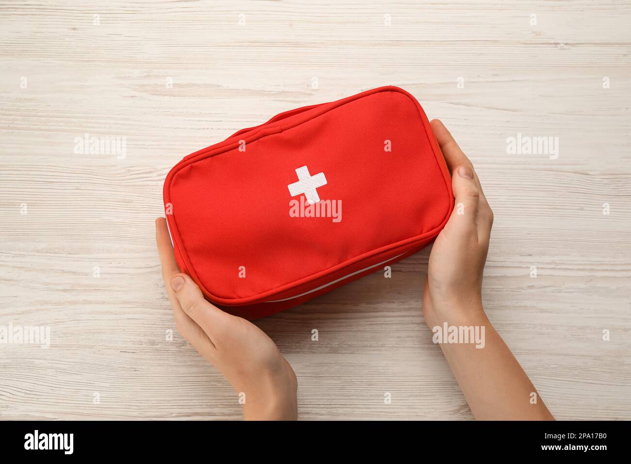 Woman holding first aid kit bag at white wooden table, top view Stock ...