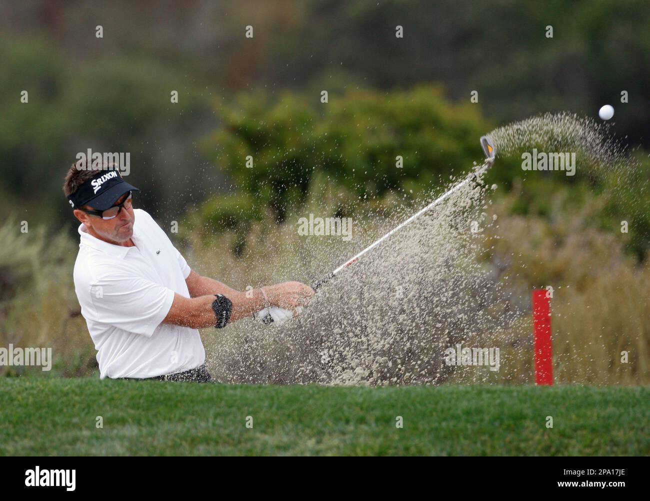 Robert Allenby of Australia blasts out of a sand trap on the 14th hole ...