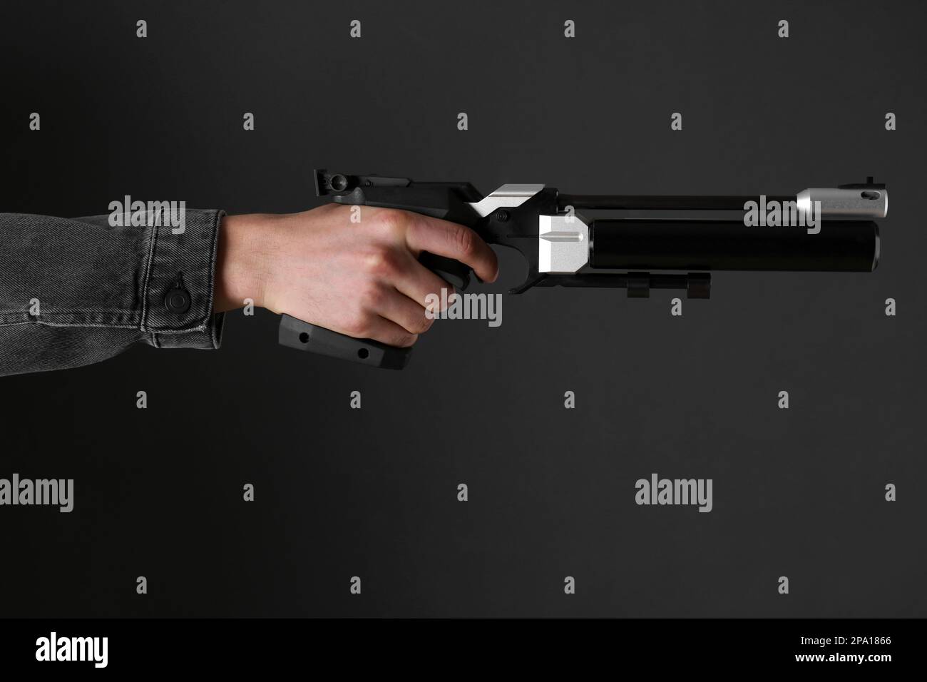 Gun shooting sport. Man aiming standard pistol on dark background ...