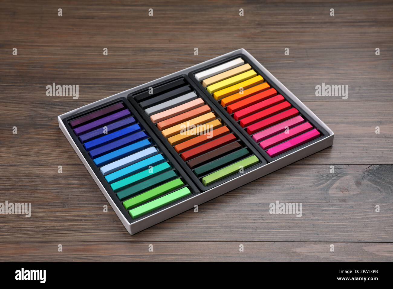 Set of colorful pastels in box on wooden table. Drawing materials Stock ...