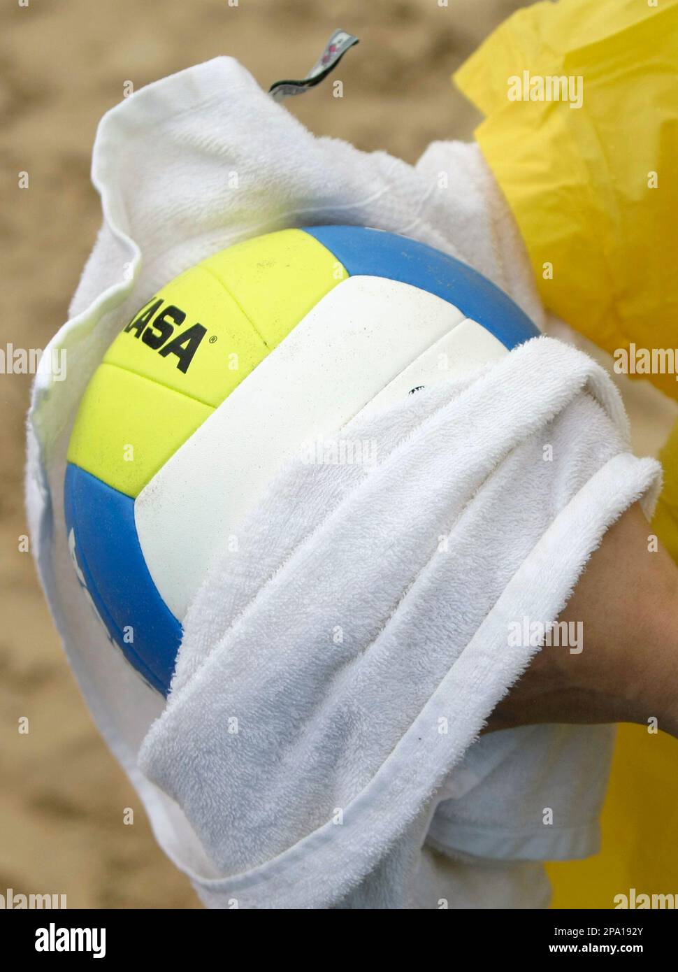 A woman dries a volleyball with a towel at the FIVB Beach Volleyball ...