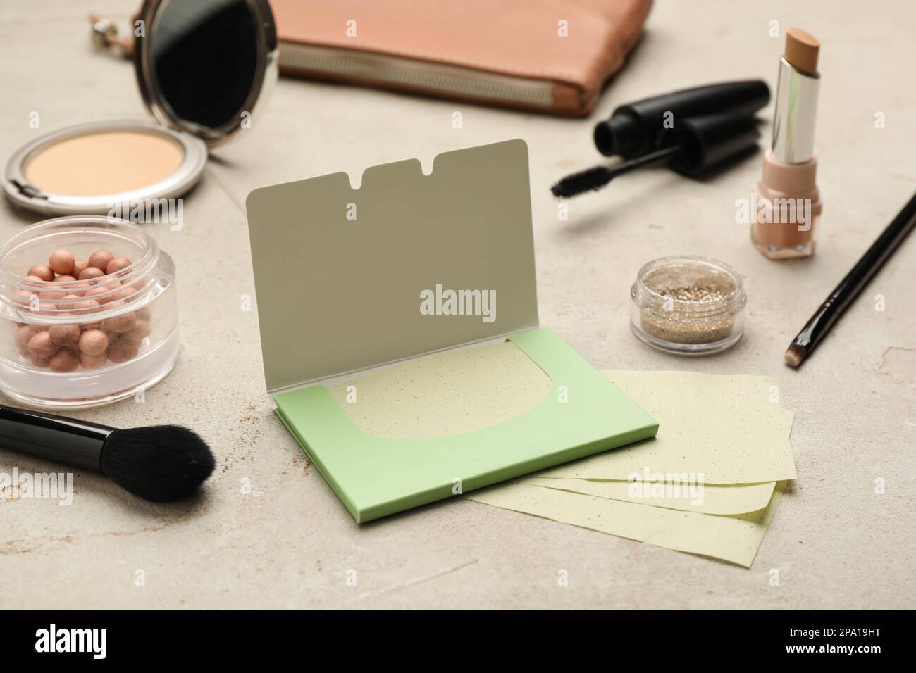 Facial oil blotting tissues and different decorative cosmetics on light ...