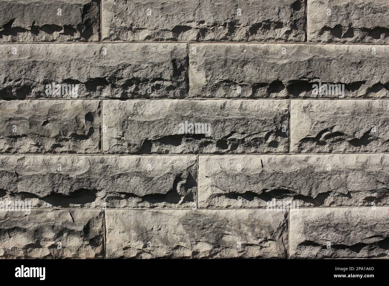A vintage traditional stone wall with layers of huge blocks of natural ...