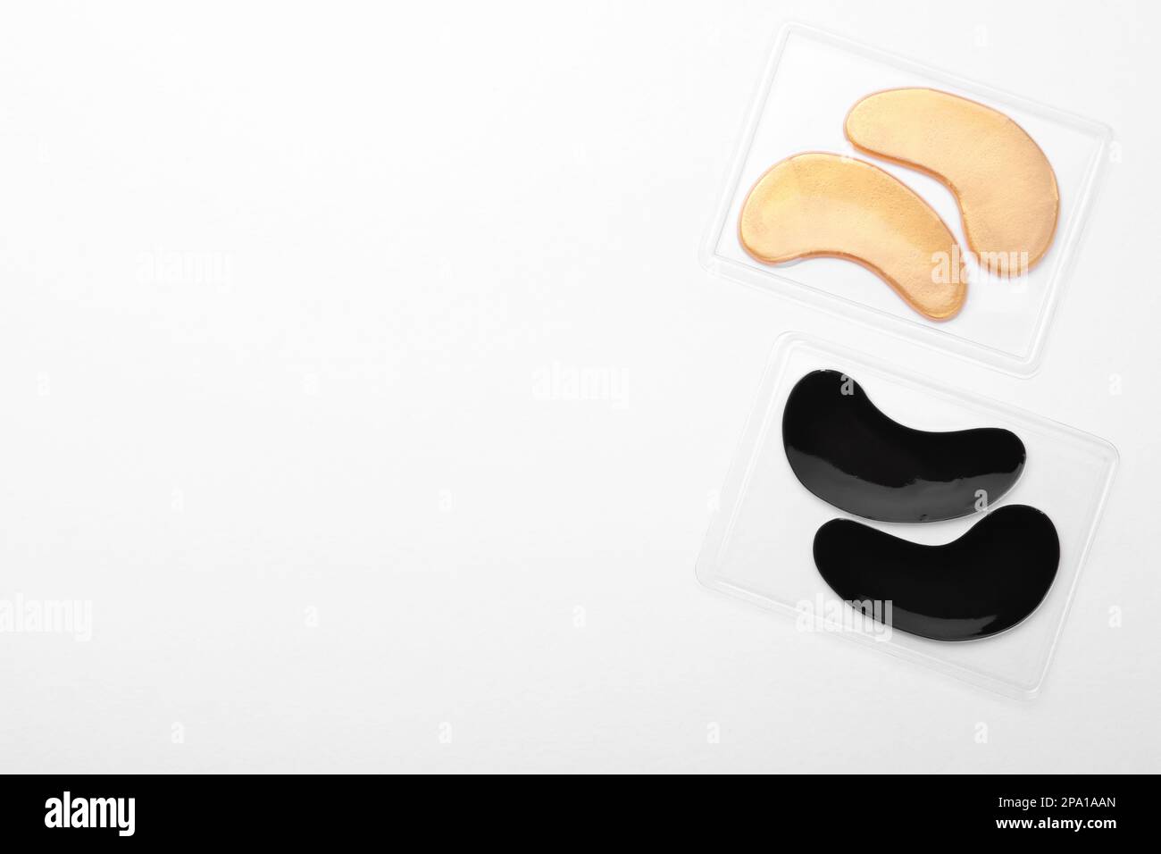 Packages with under eye patches on white background, top view. Cosmetic ...