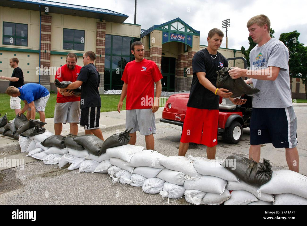 From right, Iowa Cubs employees Ross Claussen, hands a sandbag to Adam ...