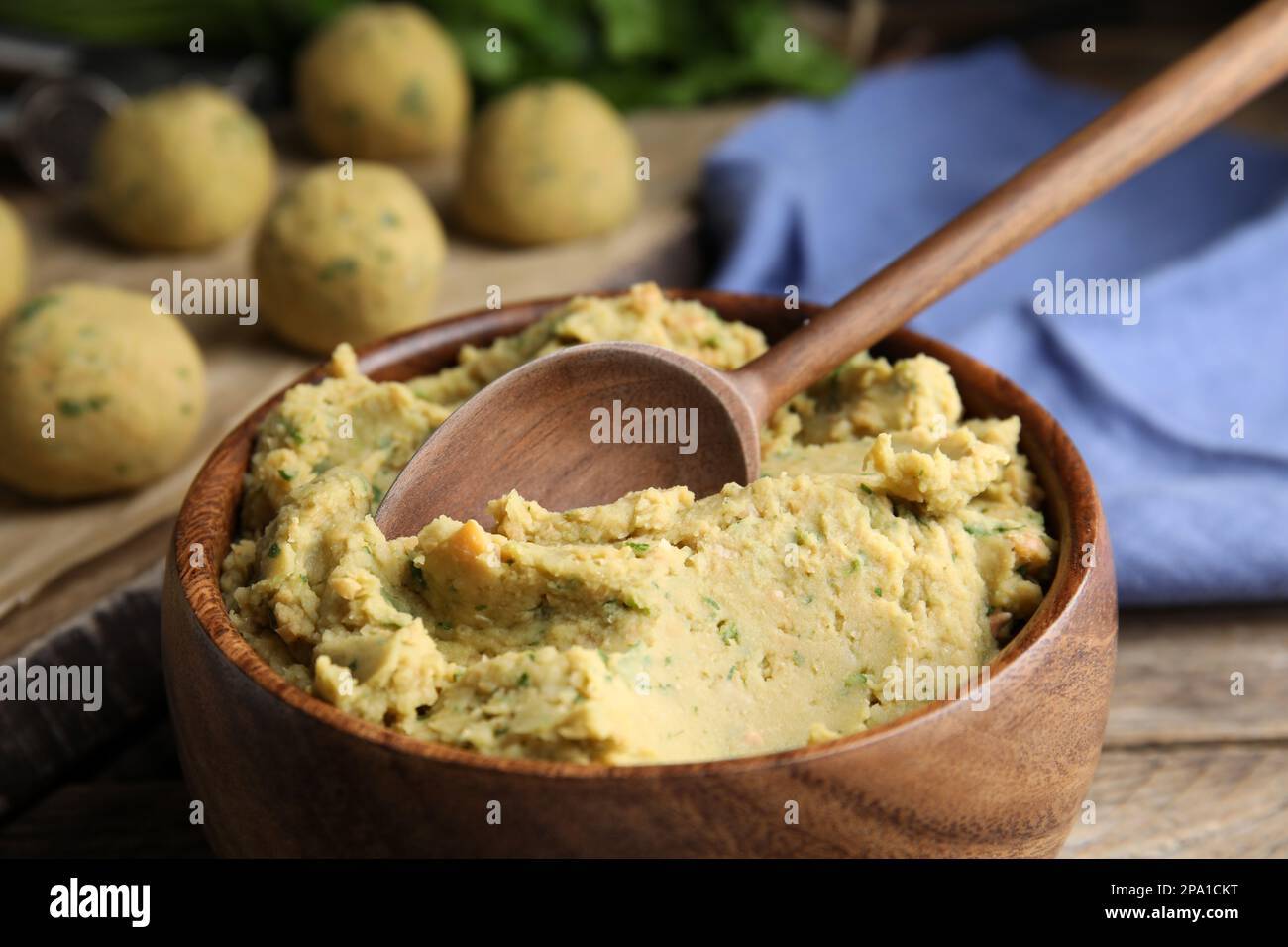 Bowl of chickpea puree with spoon on table, closeup. Falafel recipe ...
