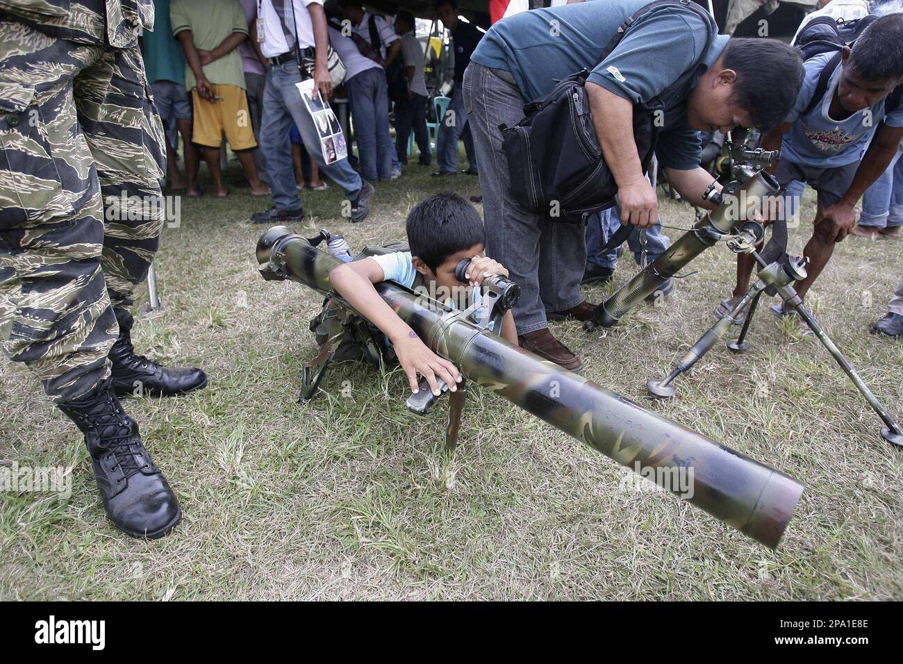 A Filipino boy checks a 90mm recoilless rifle on display during the ...