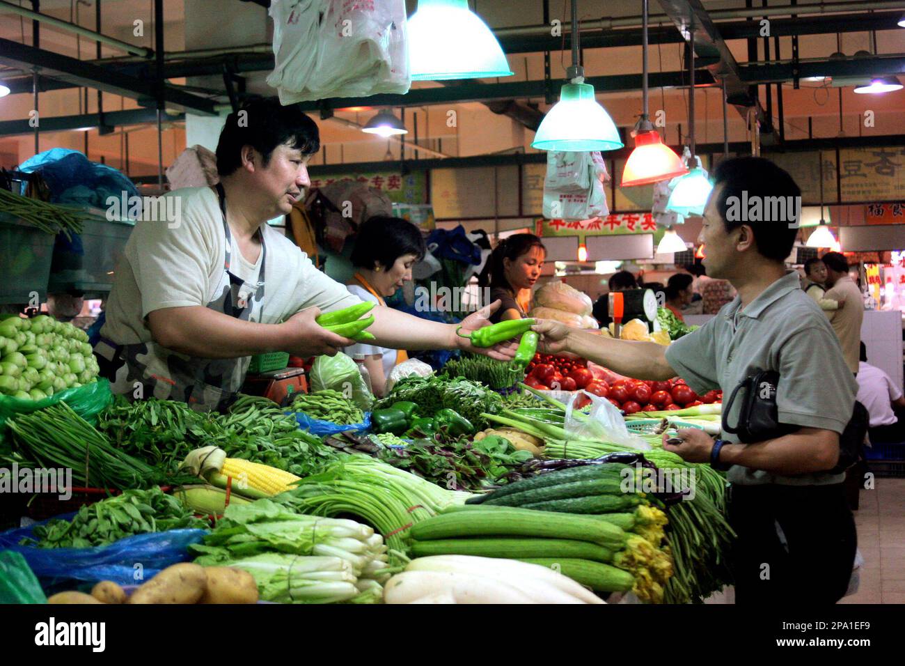 A customer buys vegetable at a market Thursday June 12, 2008 in ...