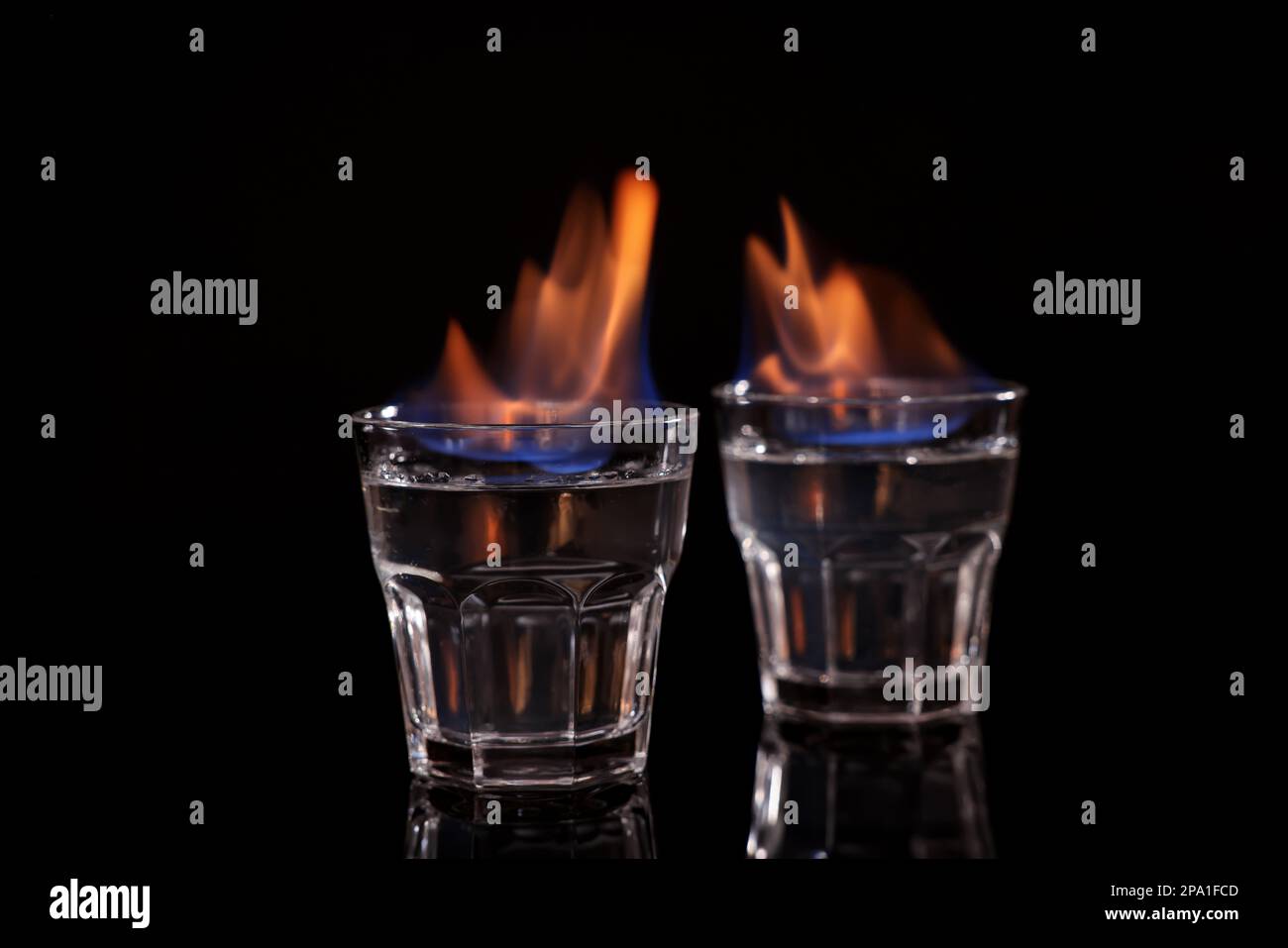Flaming vodka in shot glasses on black background Stock Photo - Alamy