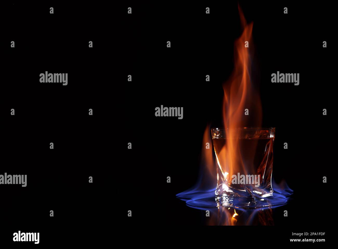 Glass with flaming vodka on black background, space for text Stock ...