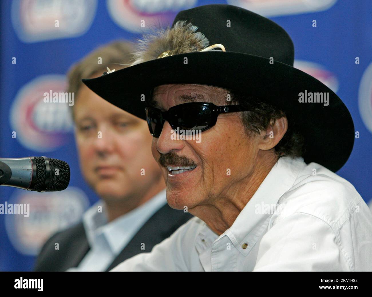 Richard Petty, right, speaks as NASCAR CEO Brian France, back, looks on ...