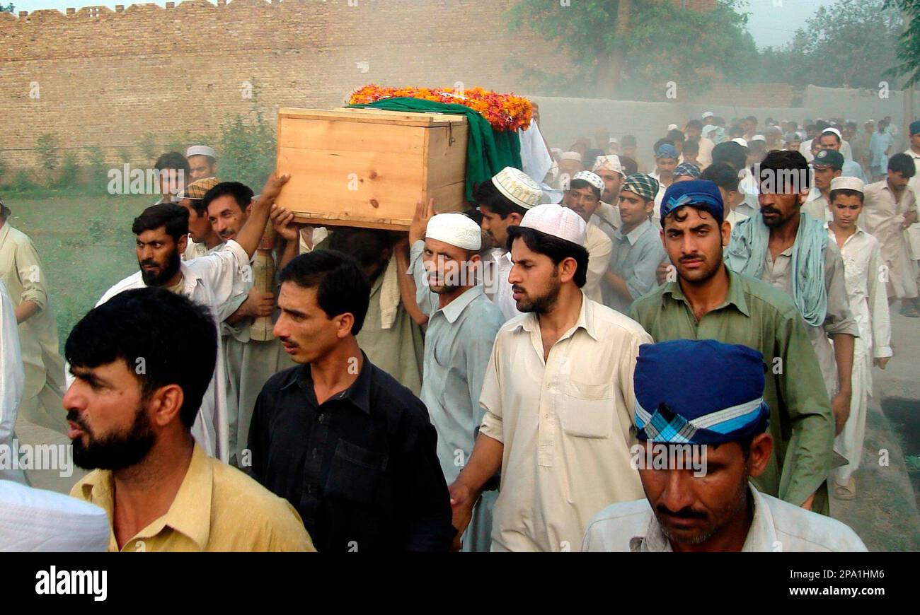 Pakistani villagers carry a coffin of Pakistan's paramilitary soldier ...