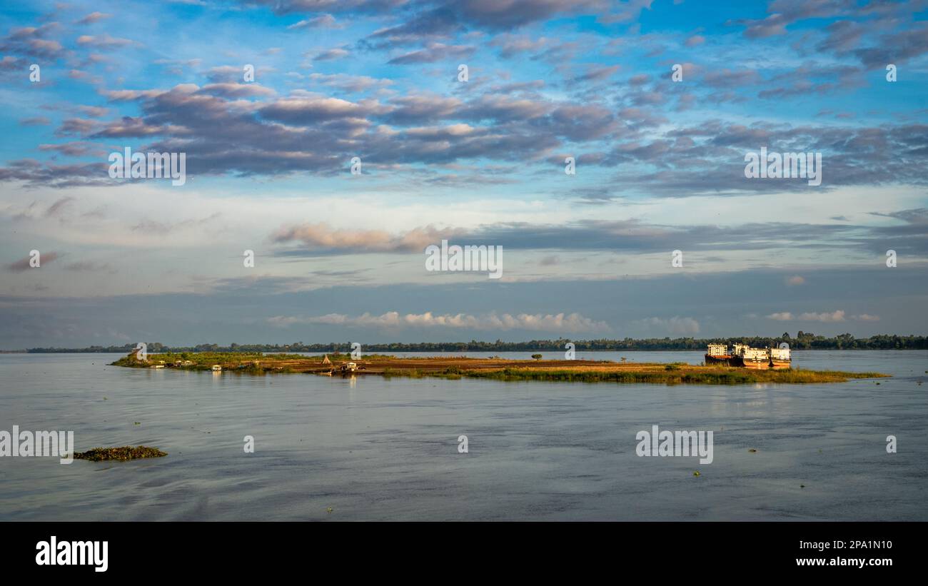Two small cargo ships tied up on a small islet midstream in the Mekong ...