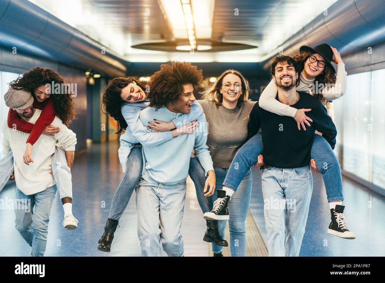 Happy friends having fun inside underground metropolitan station - Soft ...