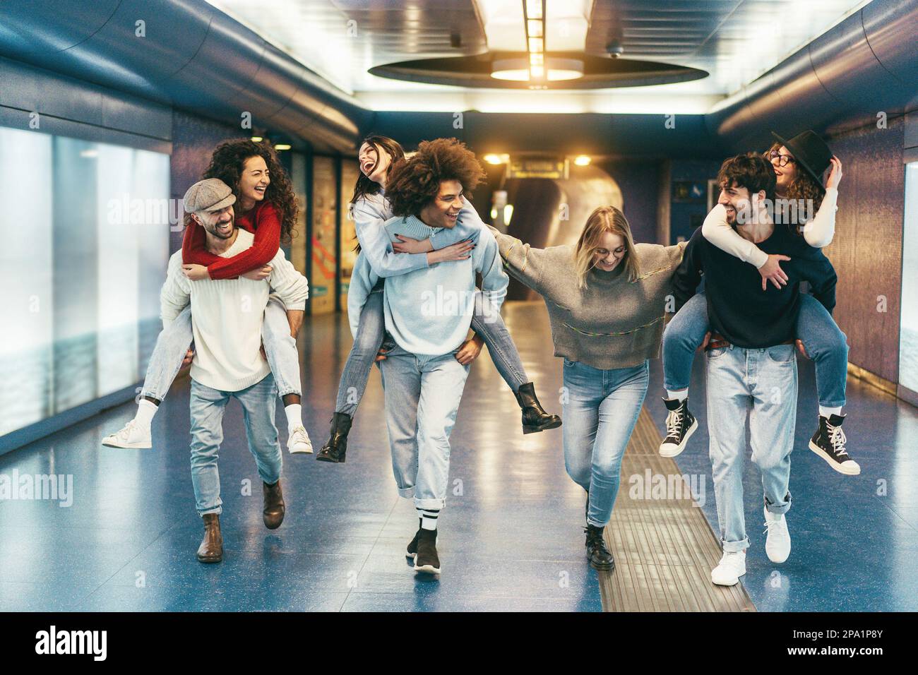 Happy friends having fun inside underground metropolitan station - Soft ...