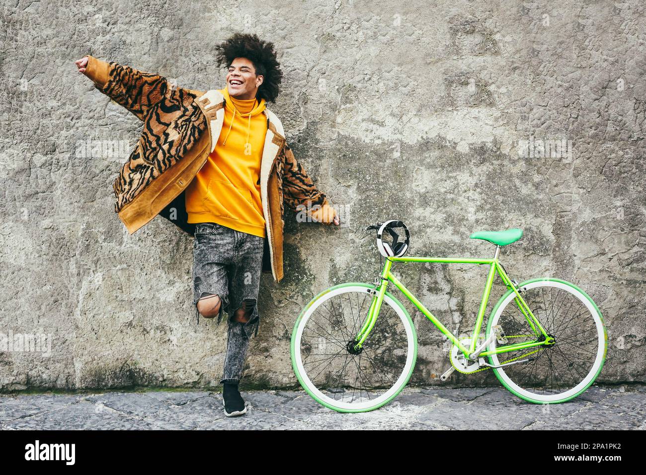 Young african boy having fun with his bicycle outdoor in the city ...