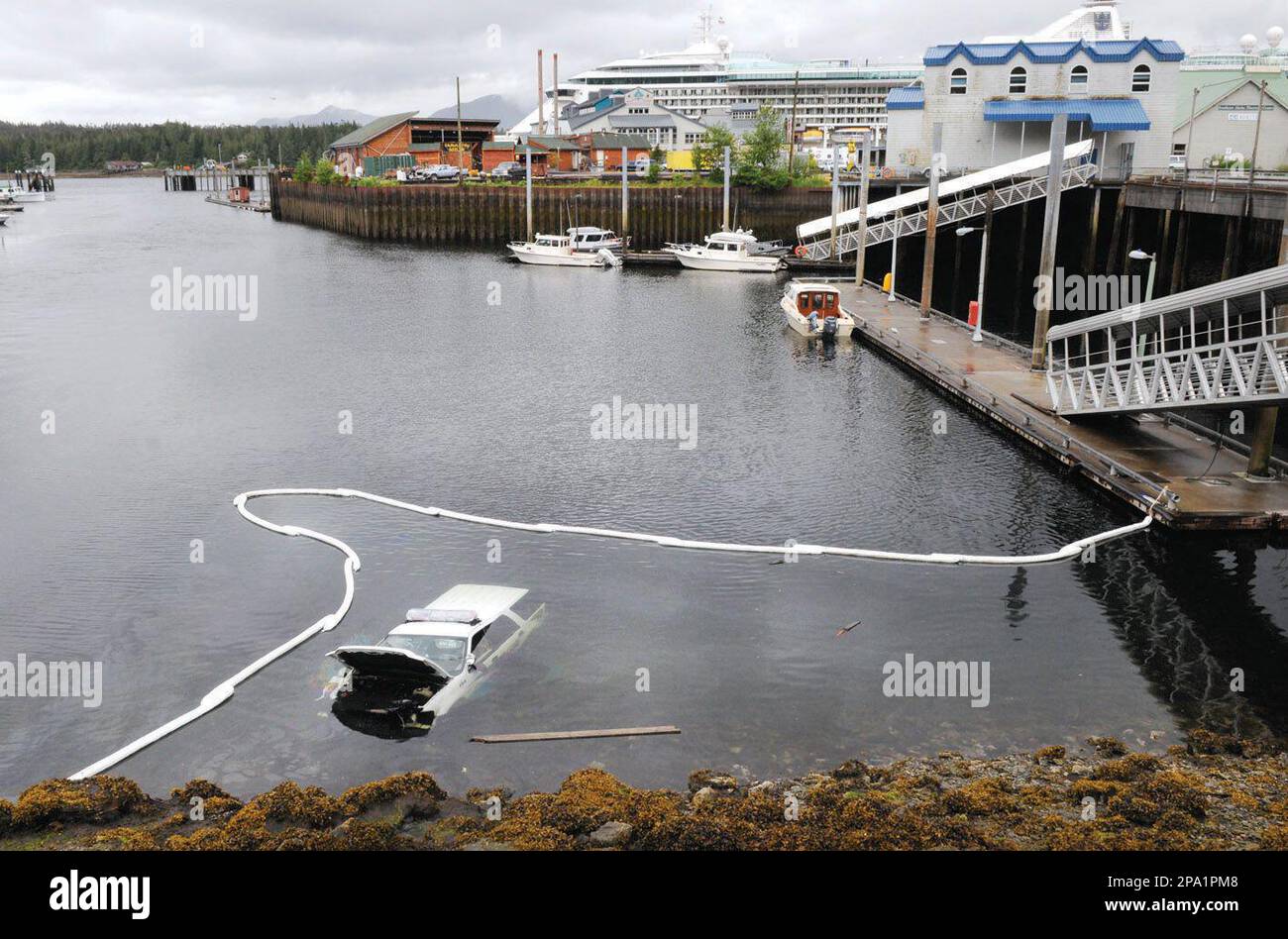 A white oil containment boom surrounds a police vehicle on Sunday, June ...