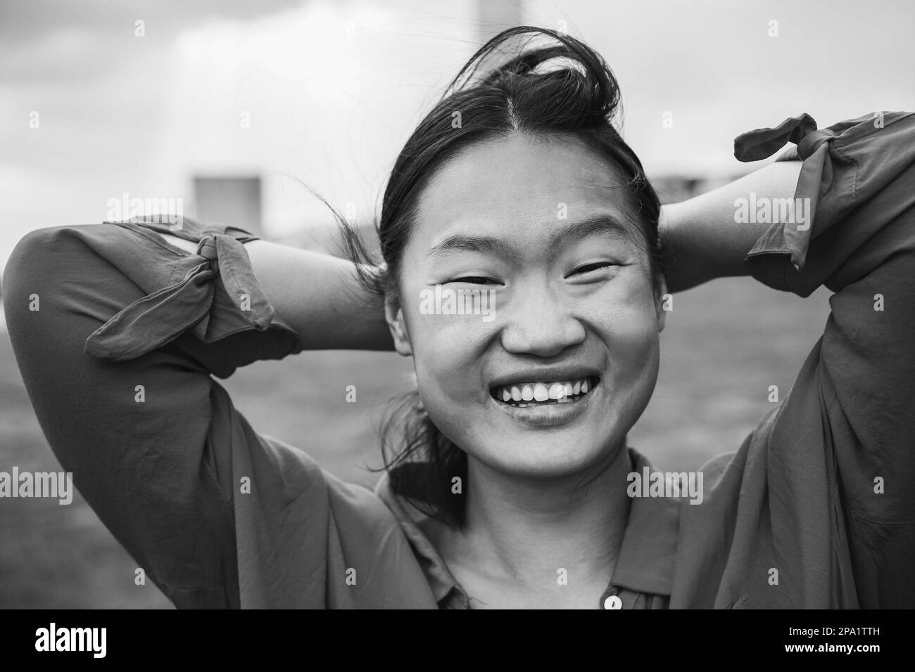 Young asian girl smiling on camera outdoor - Focus on face - Black and ...