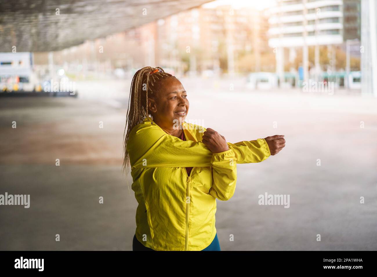 Senior african woman stretching during workout routine outdoor - Focus ...