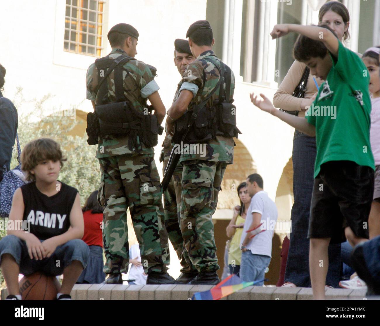 Lebanese holiday makers play in front of Army soldiers at Al Najma ...