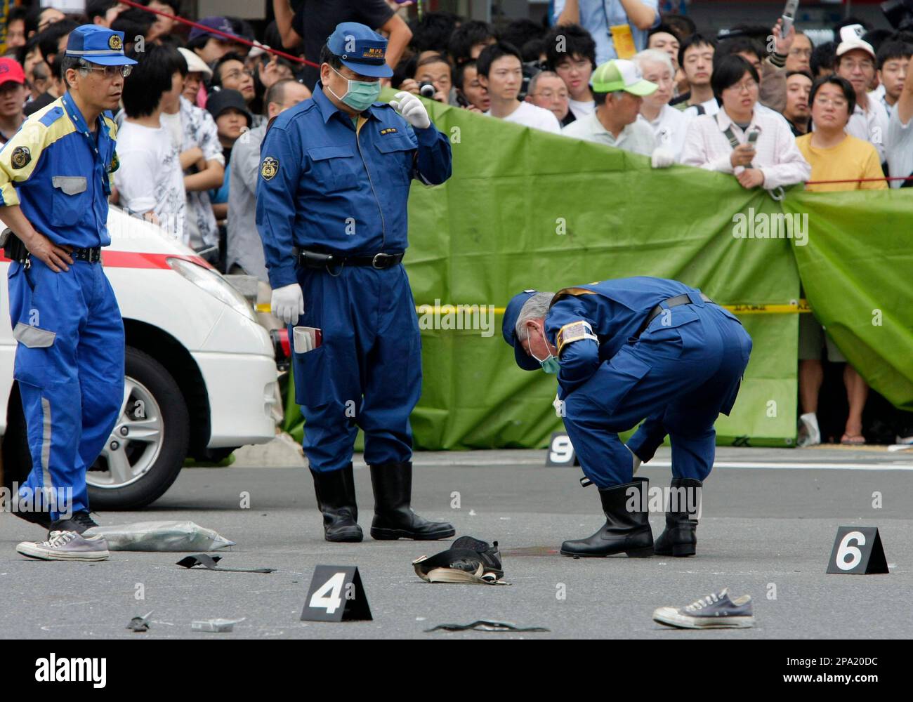 Police investigators examine the crime scene of Akihabara district in ...