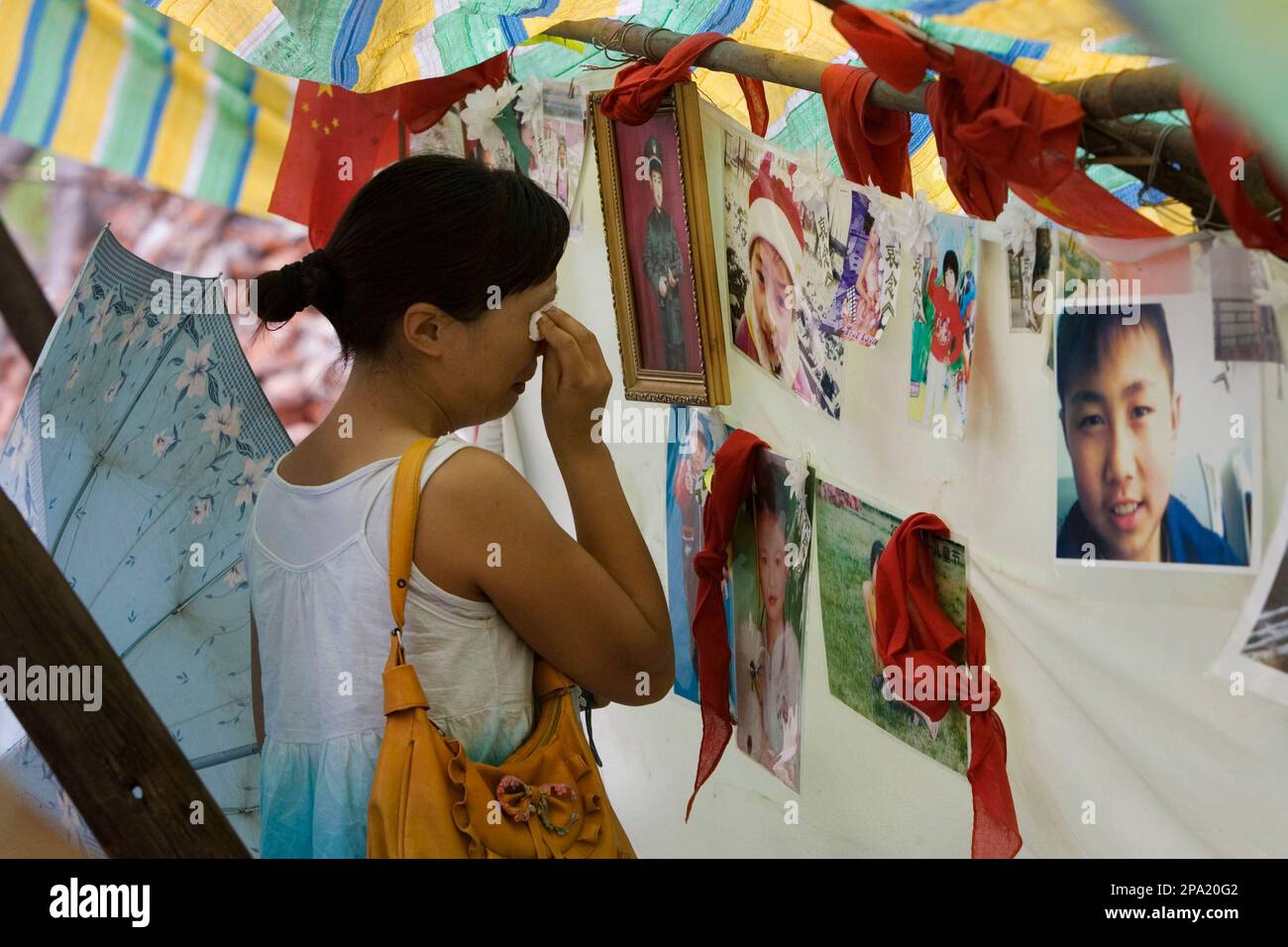 A Chinese woman weeps as she looks at portraits of children who died ...