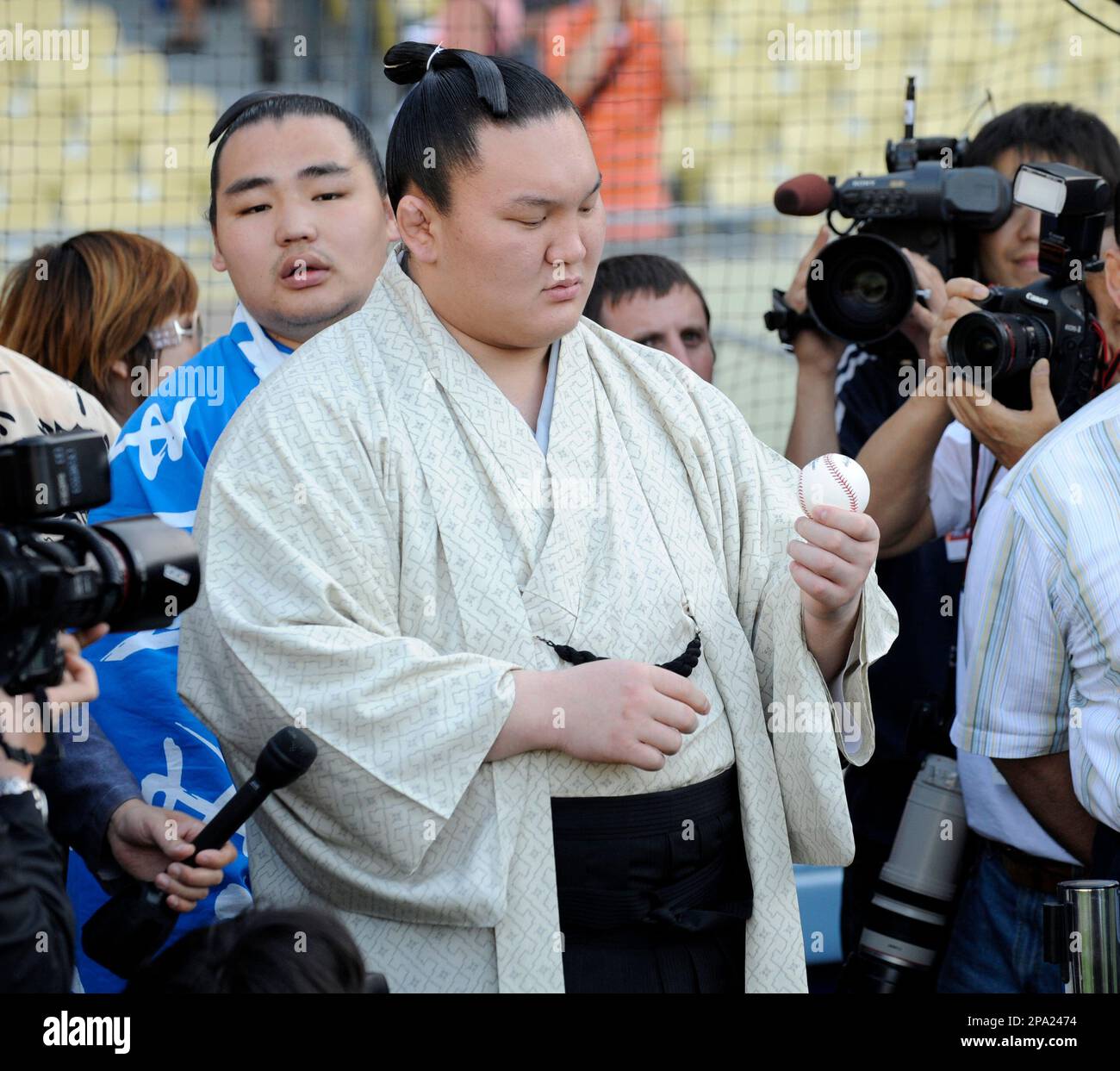 Mongolian sumo wrestler Hakuho inspects a baseball before a Major ...