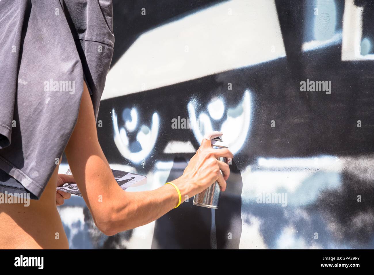 This anonymous artist is finishing his graffiti during a sunny day in ...