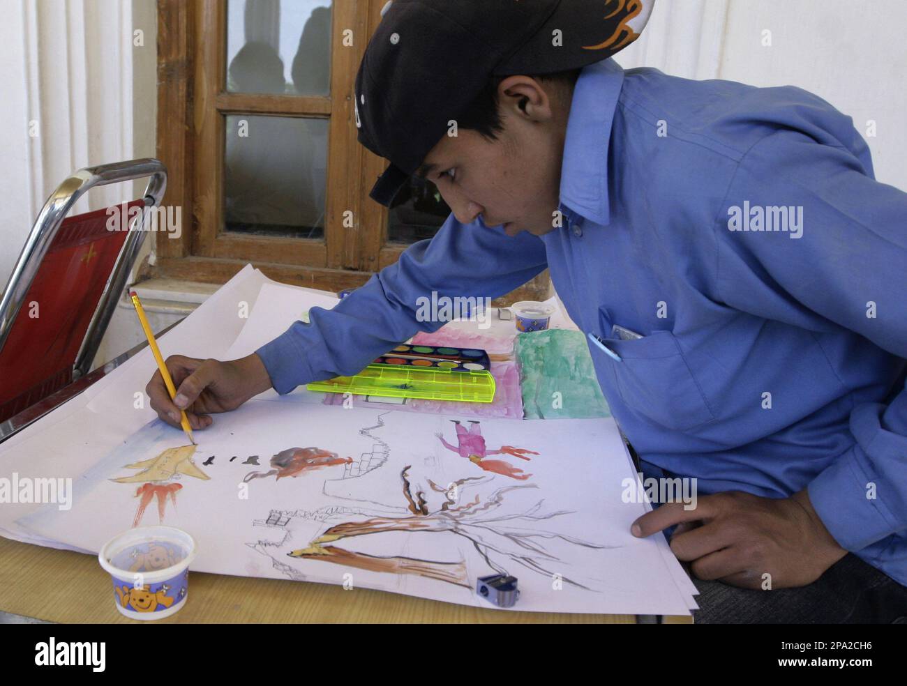 An Afghan boy draws painting of a Jet drops bombs during a children’s ...