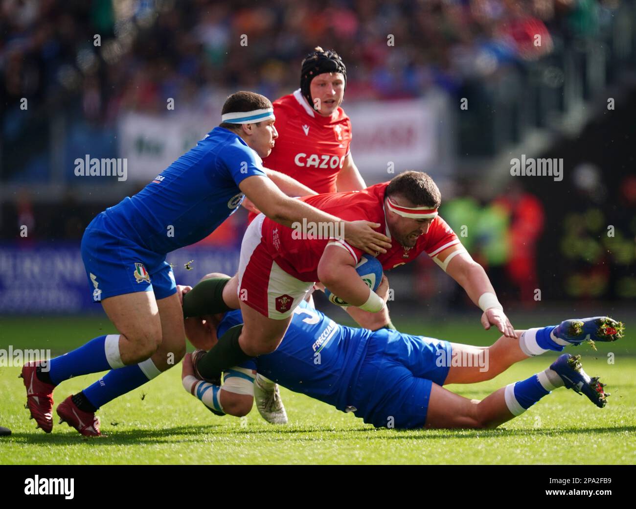 Wales' Wyn Jones (centre) is tackled by Italy's Giacomo Nicotera (left ...